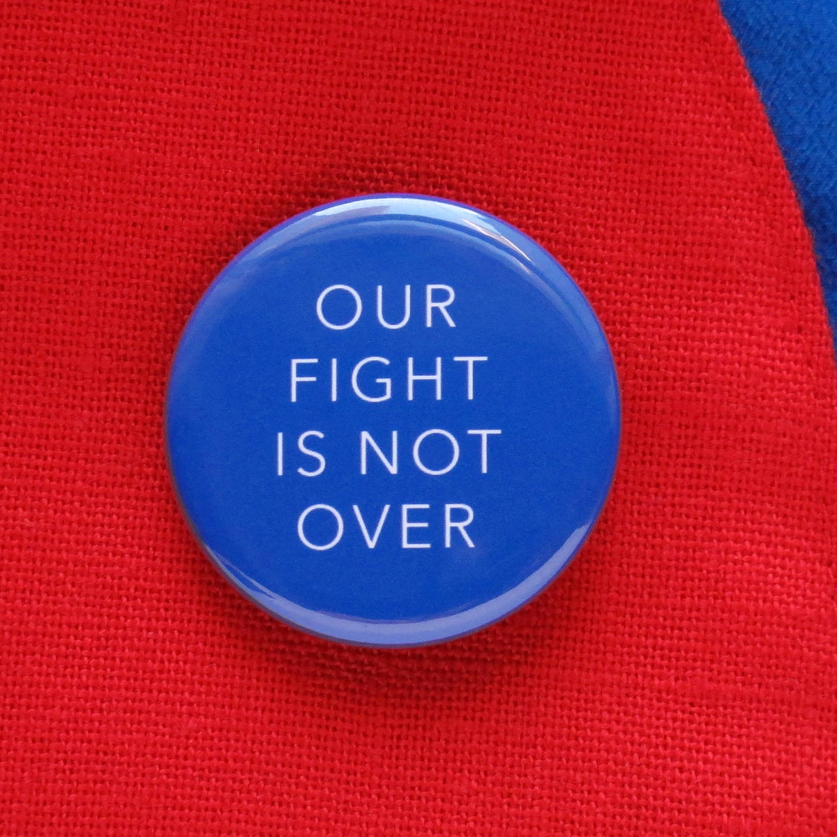 OUR FIGHT IS NOT OVER Pinback Button – WORD FOR WORD Factory